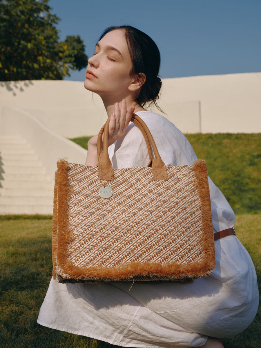 Diagonal woven panel tote bag with faux shearling trim and dual straps ...